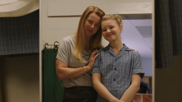 Hannah tries on her new uniform with her mother by her side.